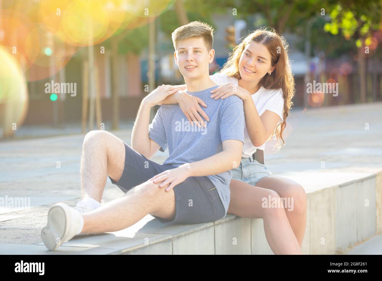Girl is sitting with young man and hugging him Stock Photo - Alamy