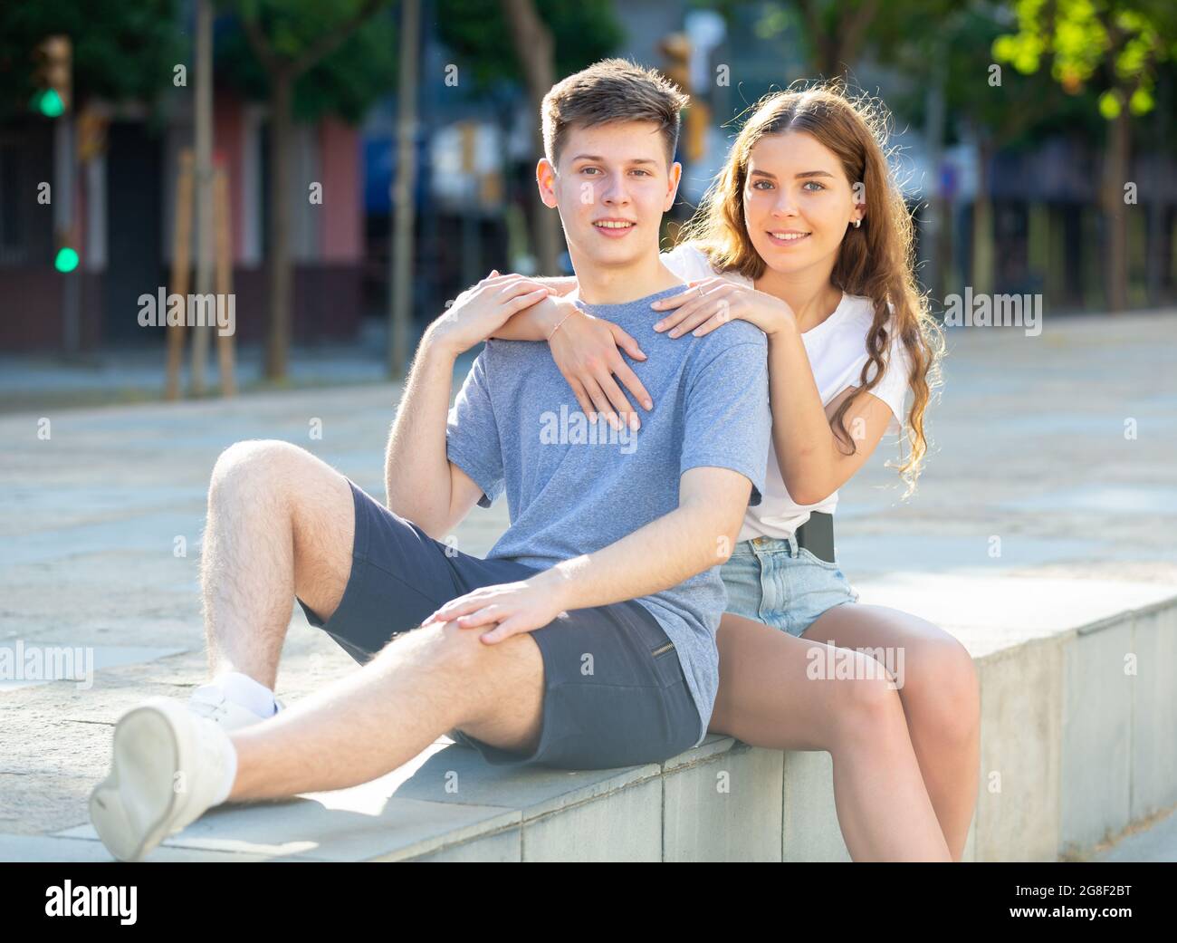 Girl is sitting with young man and hugging him Stock Photo - Alamy