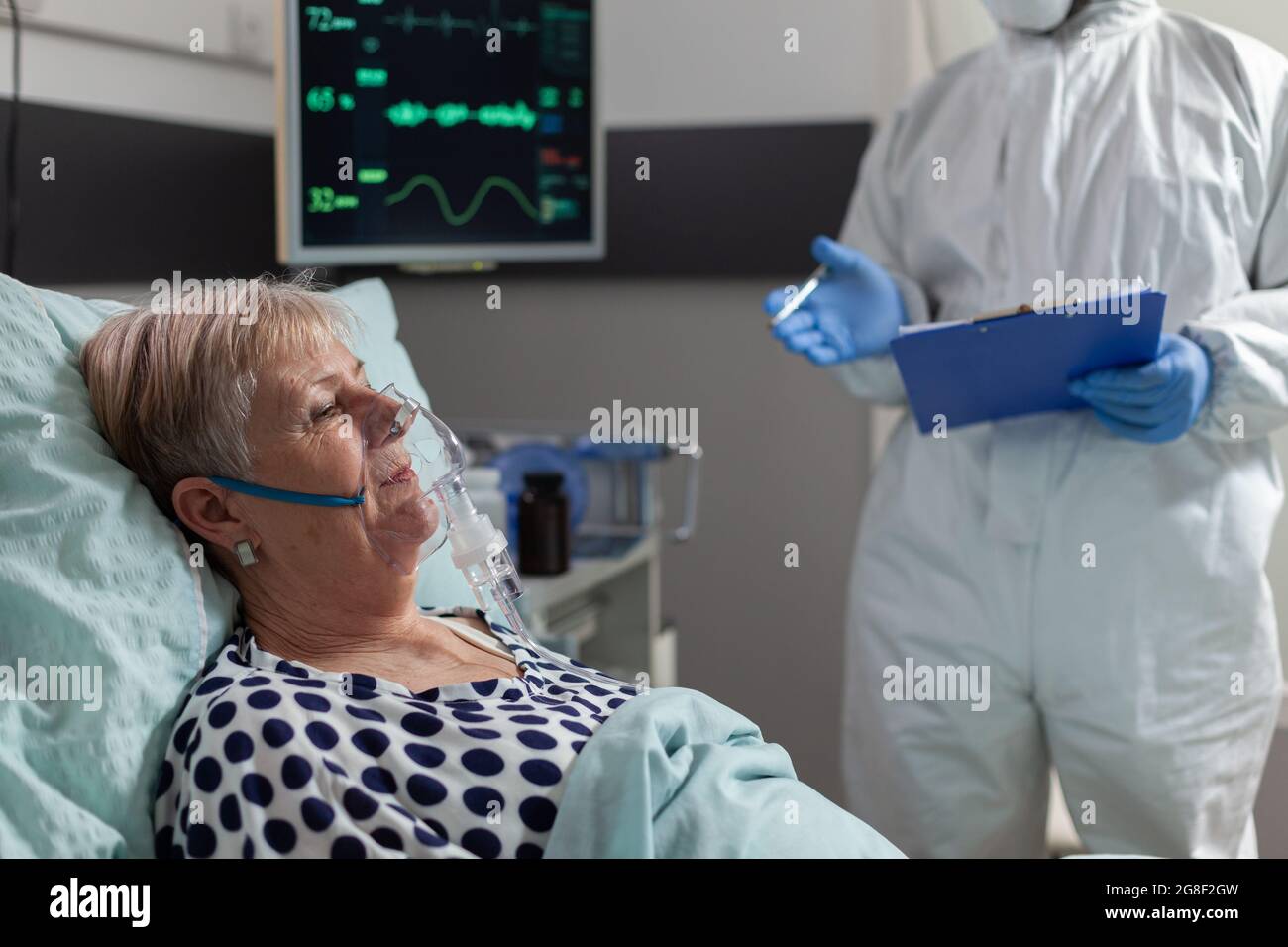 Sick senior woman inhale and exhale through oxygen mask laying in ...
