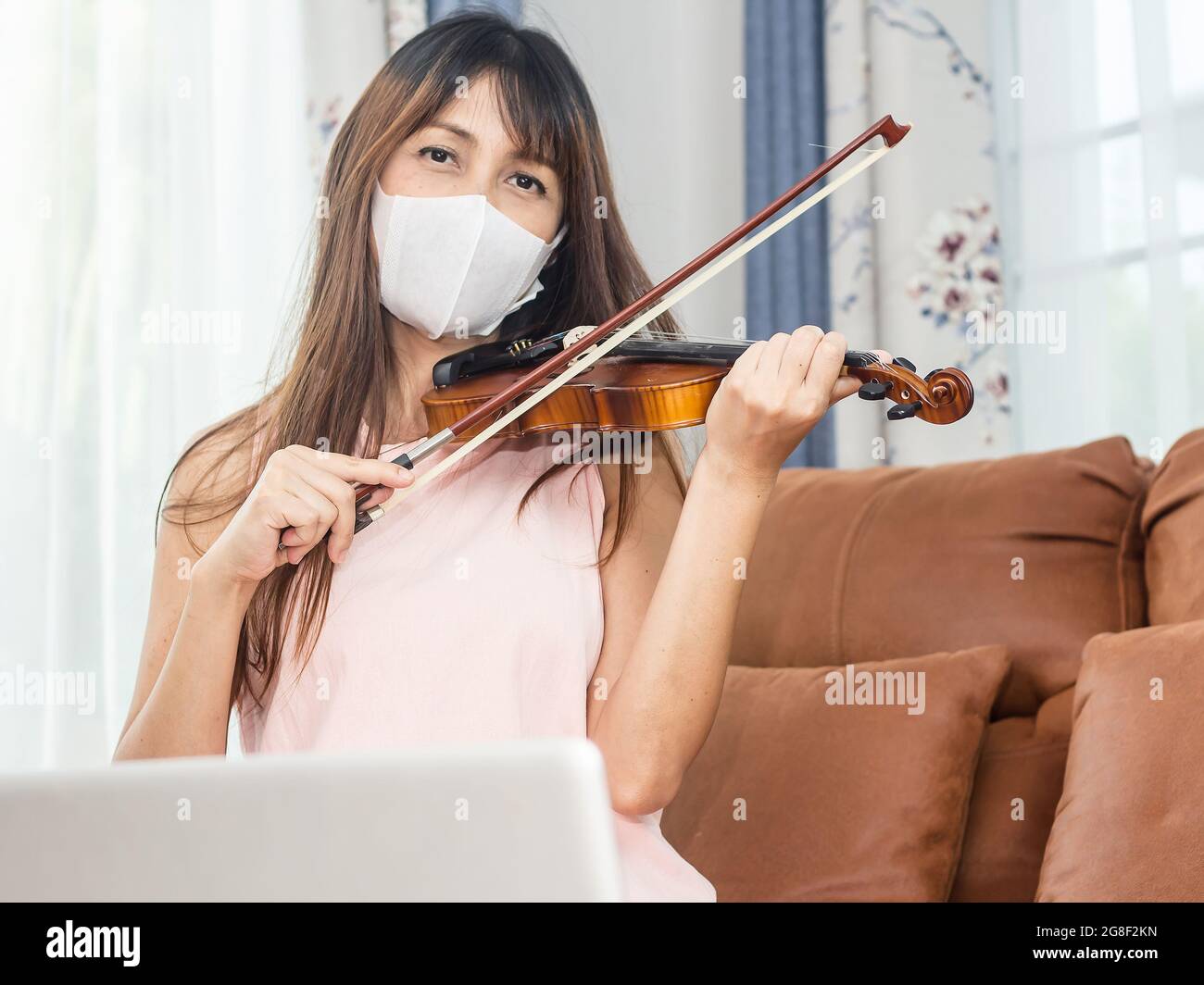 Women wear a mask and learn how to play the violin from their home ...