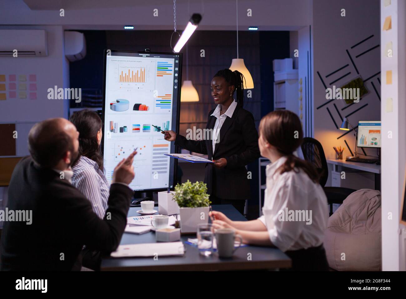 Workaholic african american leader standing in front of presentation ...