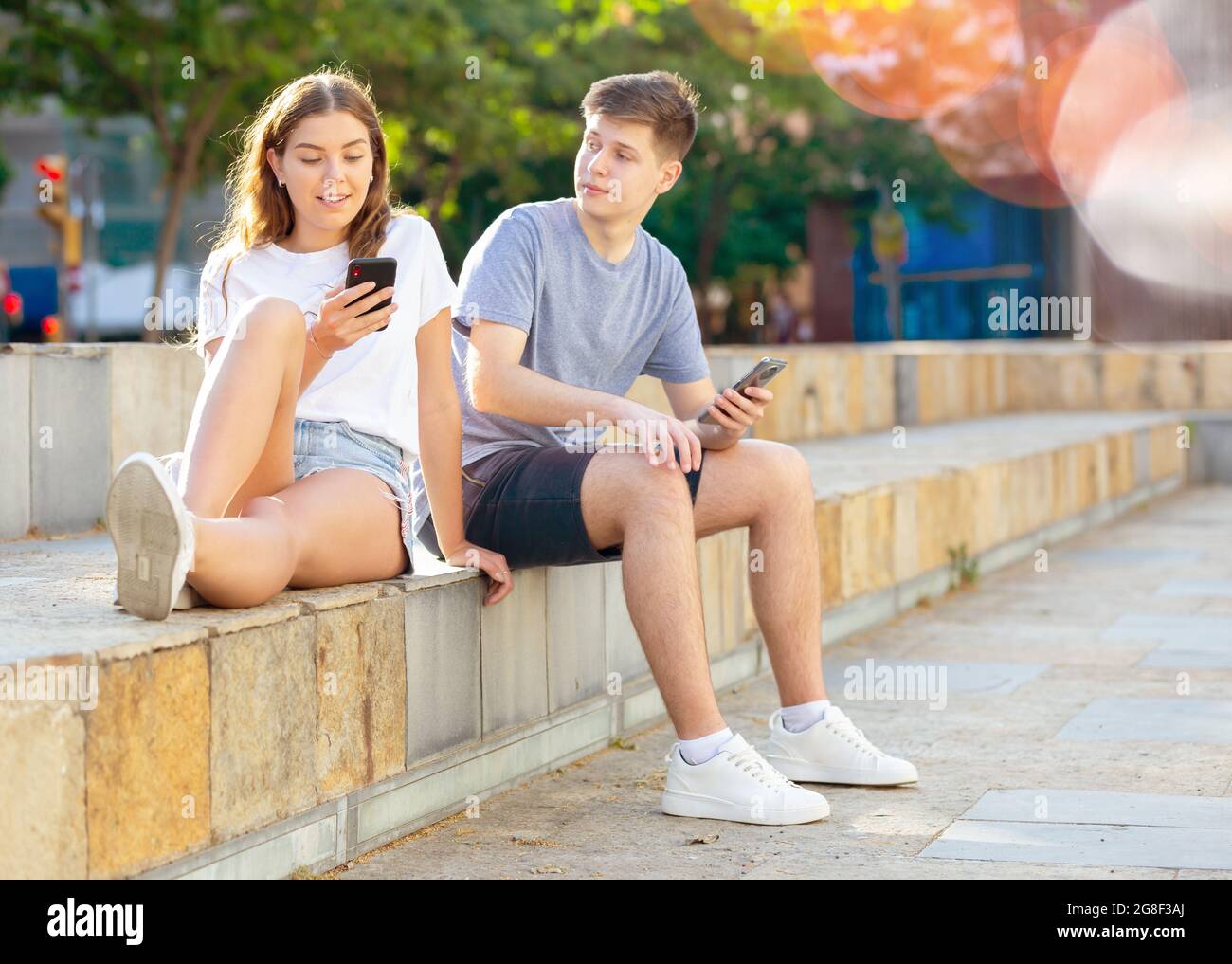 Two teenagers chatting on their smartphone Stock Photo - Alamy