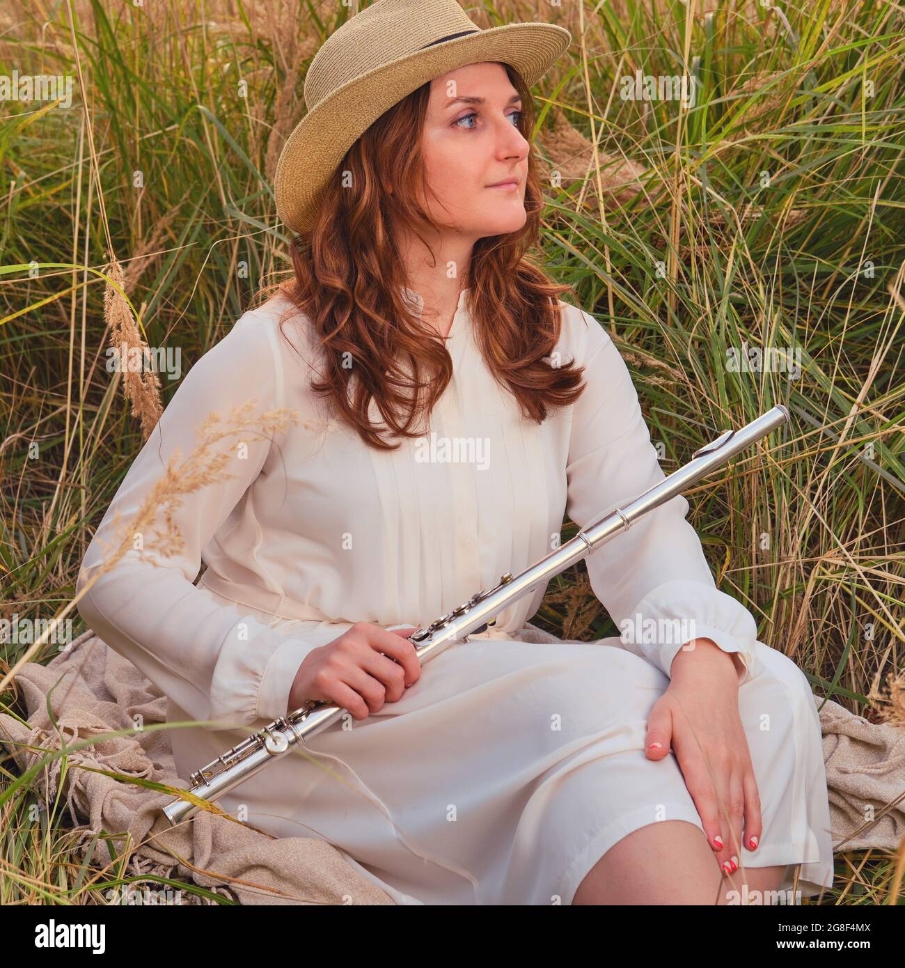 A young woman musician with a flute among the yellow autumn grass Stock ...
