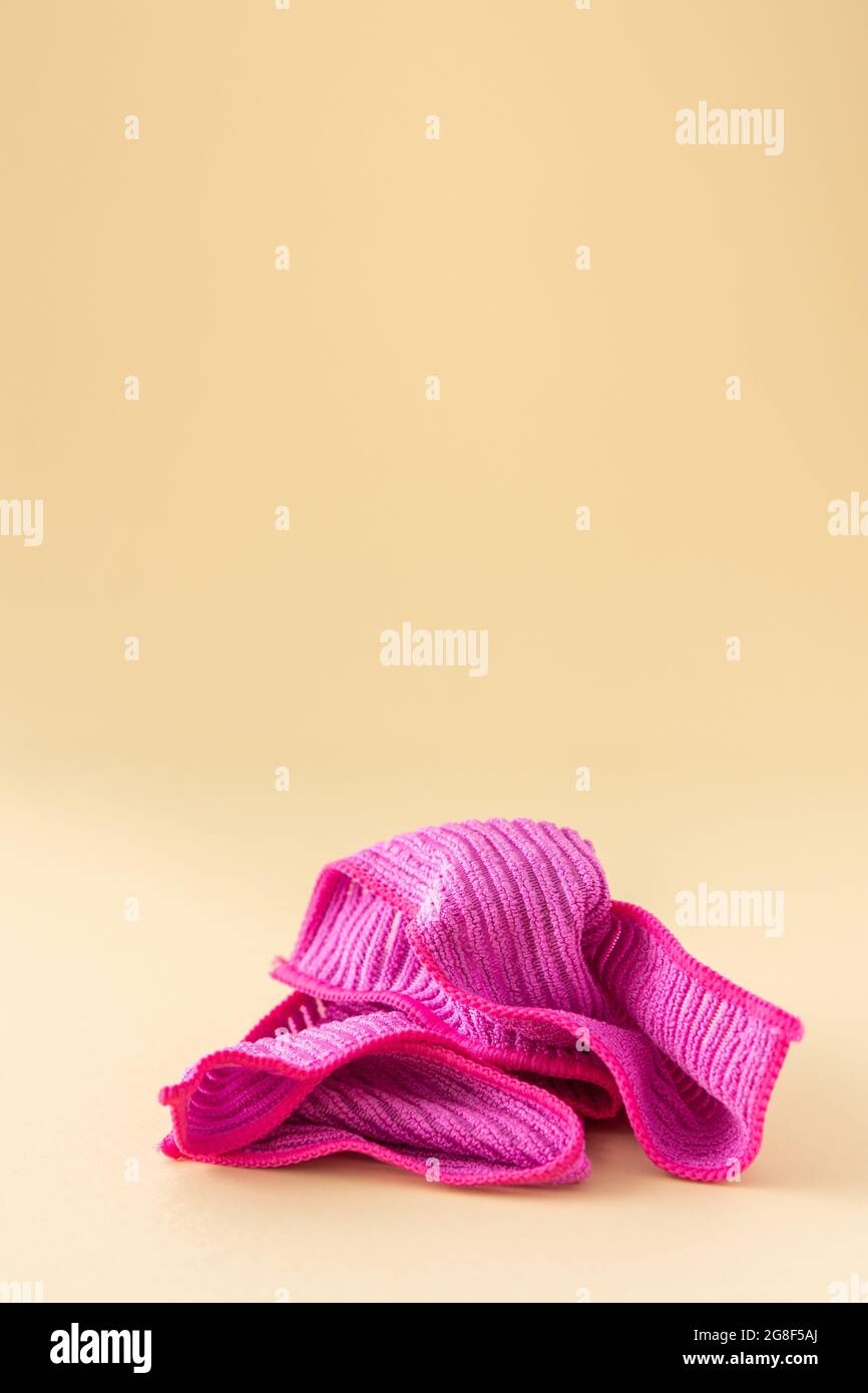 Pink microfiber cloth for washing on a neutral beige background ...