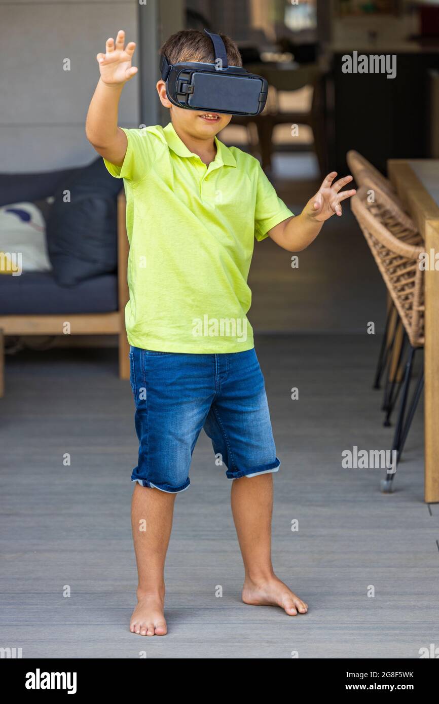 Excited little kid using virtual reality glasses Stock Photo - Alamy