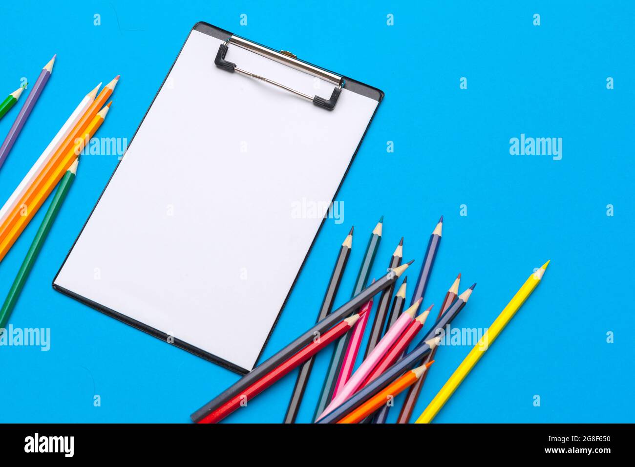 Clipboard and office supplies on blue background. Top view. Space for ...