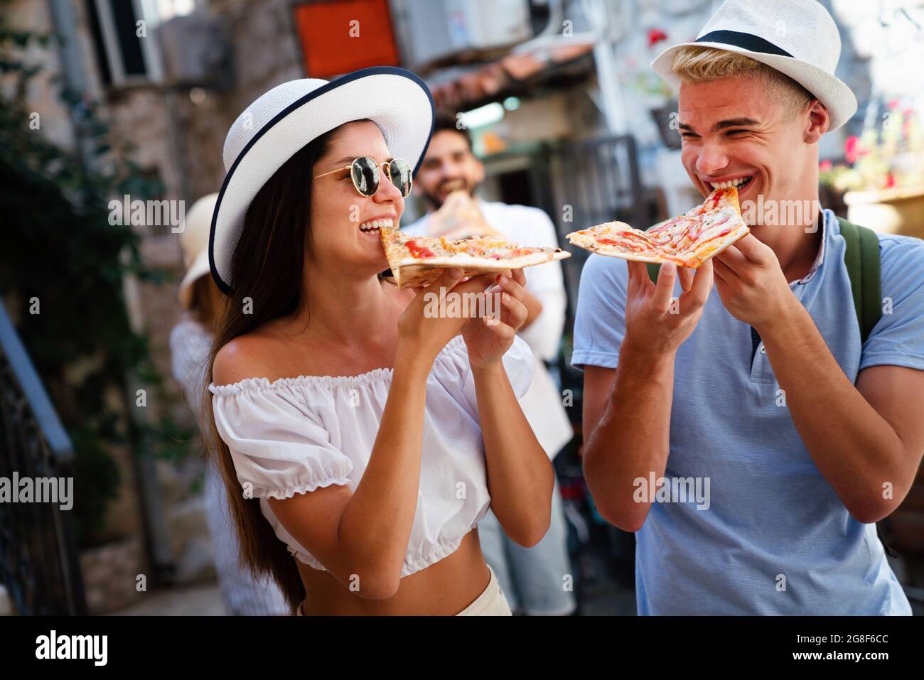 Happy traveling tourists friends having fun, eating pizza on summer ...