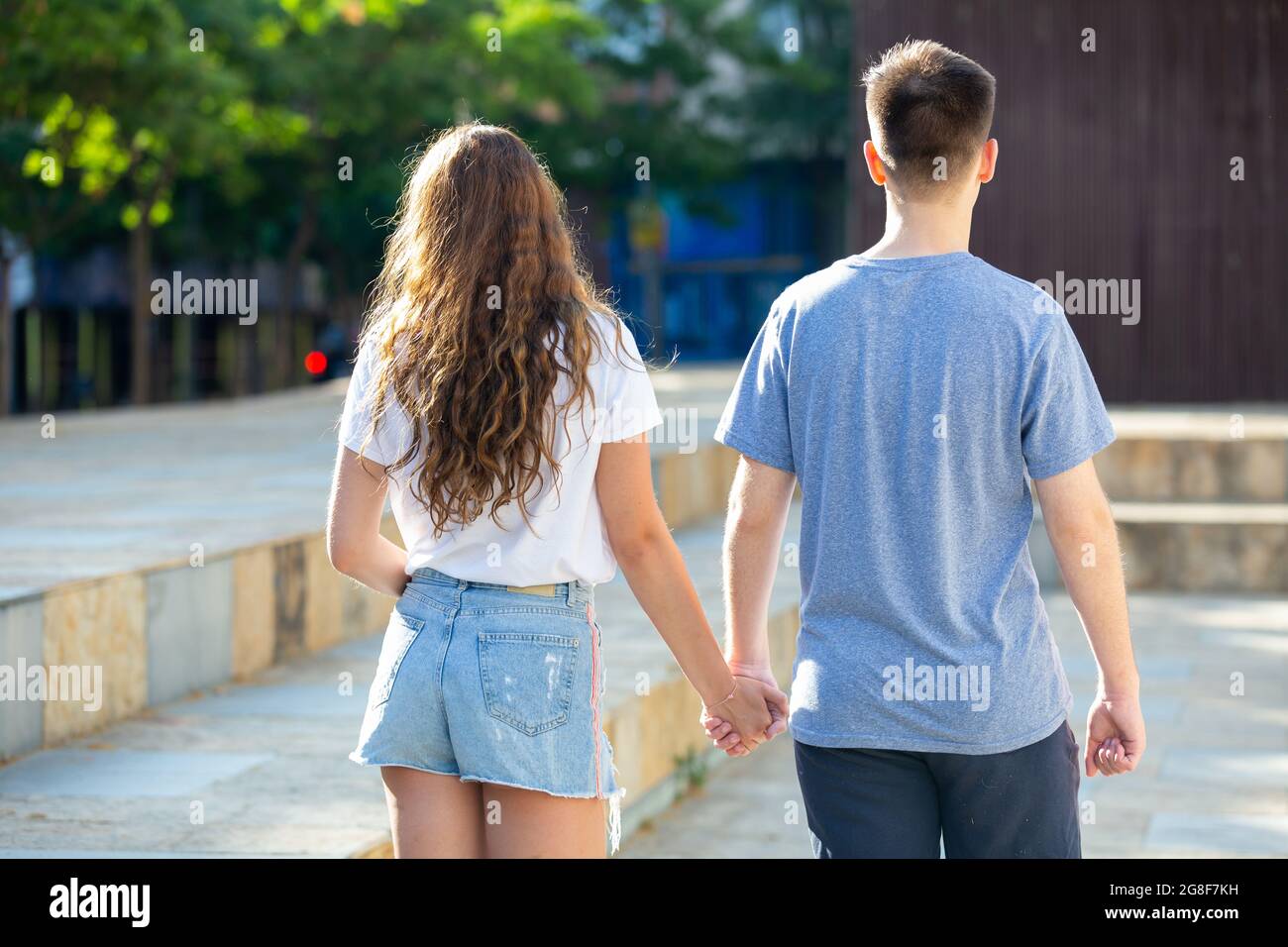 Guy and the girl go hand in hand Stock Photo - Alamy