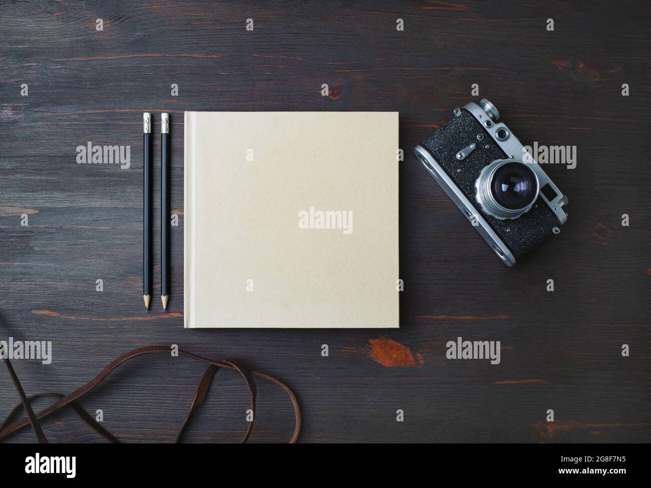 Blank stationery: book, pencils and retro camera on wood table ...