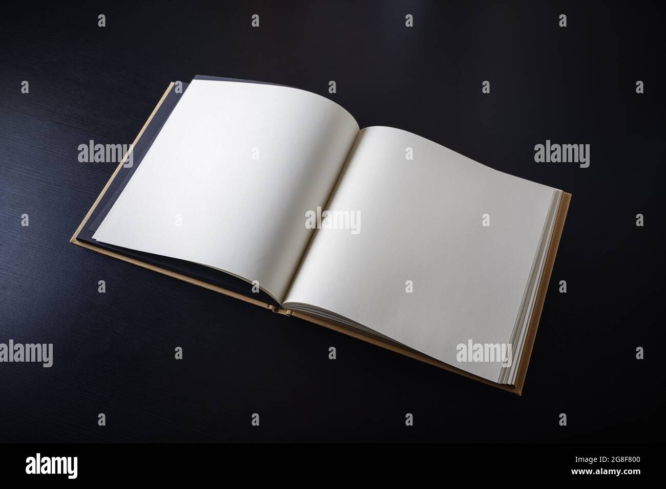 Blank open book on black paper background Stock Photo - Alamy
