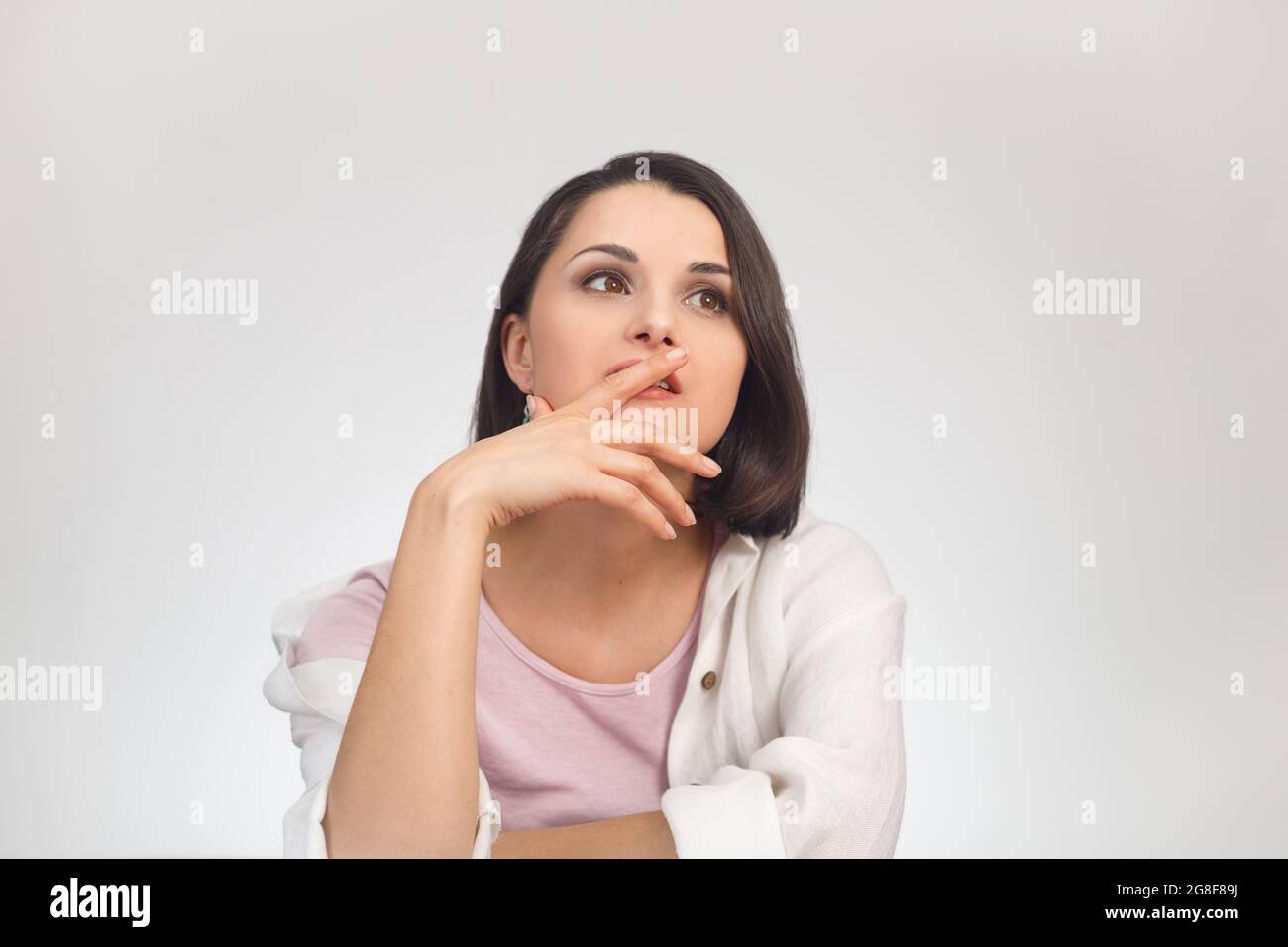 High-key studio portrait of a young dreaming brunette multiethnic woman ...