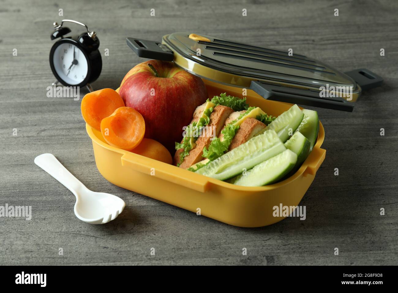 Lunch box and tasty food on gray textured background Stock Photo - Alamy
