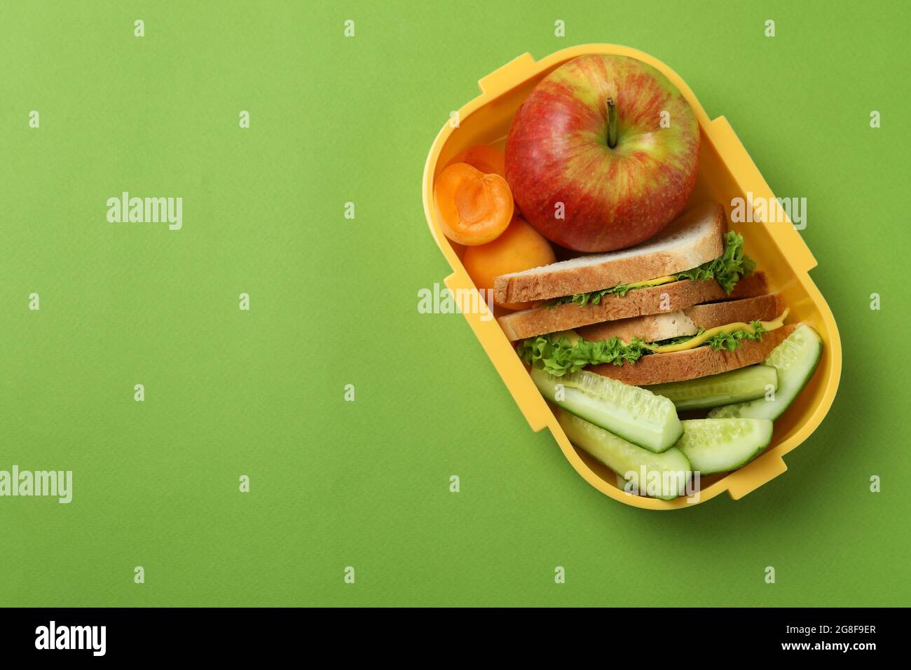 Lunch box with tasty food on green background Stock Photo - Alamy