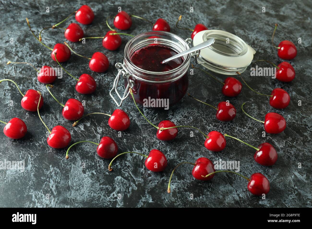 Cherry jam and ingredients on black smokey background Stock Photo - Alamy