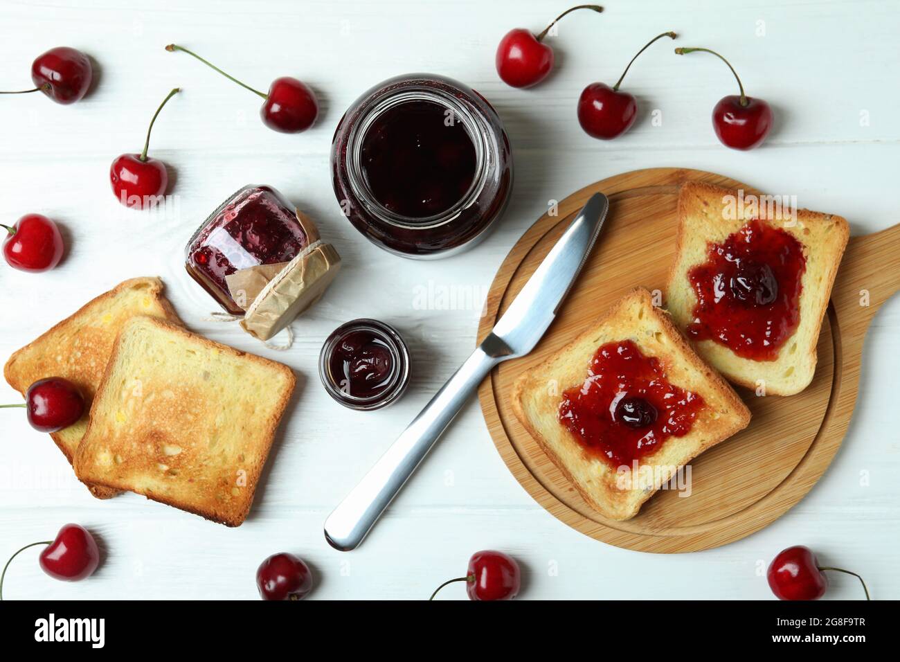 Cherry jam and ingredients on white wooden table Stock Photo - Alamy