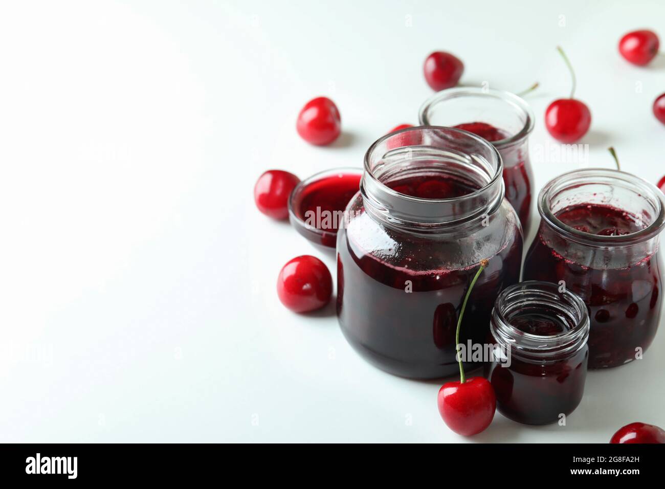 Cherry jam and ingredients on white background Stock Photo - Alamy