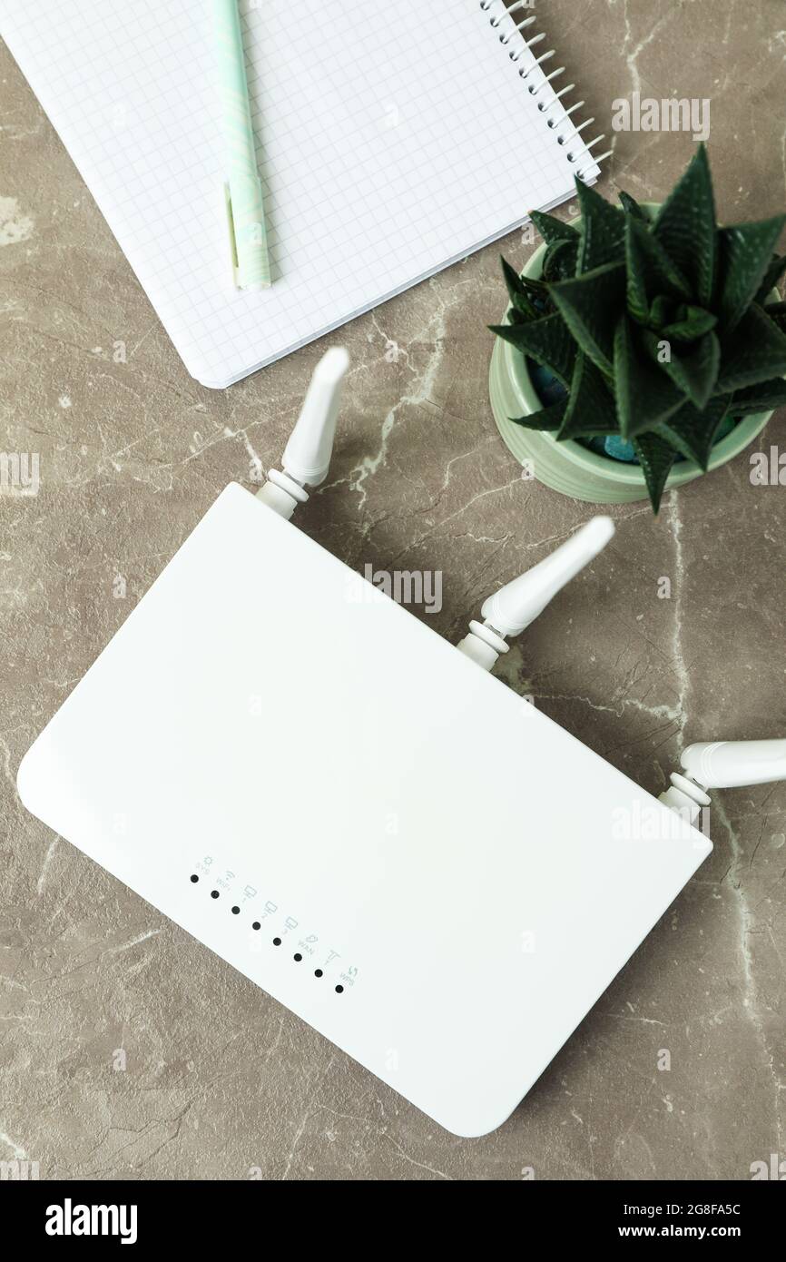 Workplace with Wi - fi router on gray textured table Stock Photo - Alamy