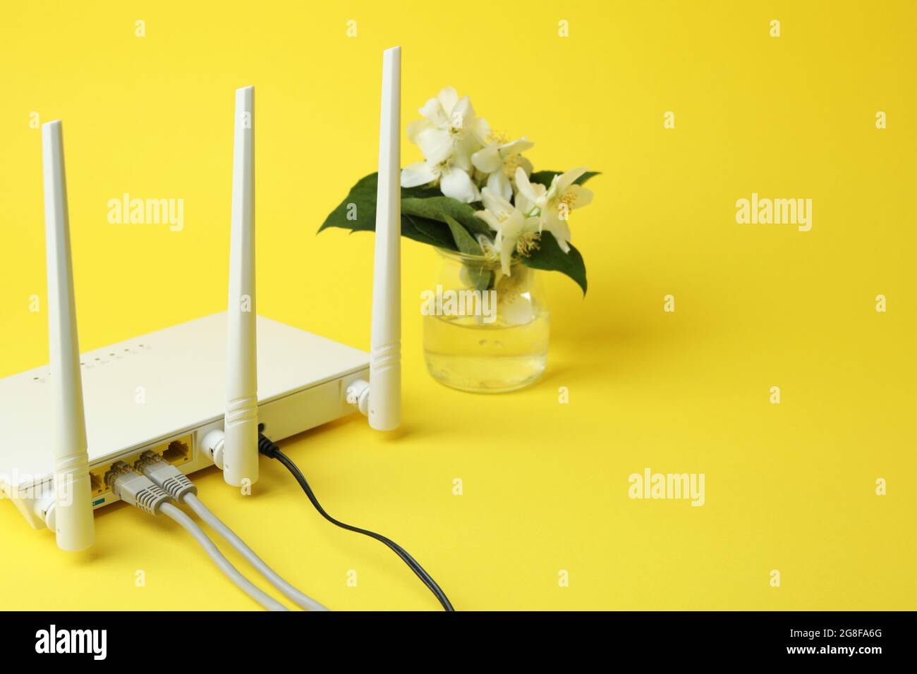 Wi-Fi router and flowers on yellow background Stock Photo - Alamy