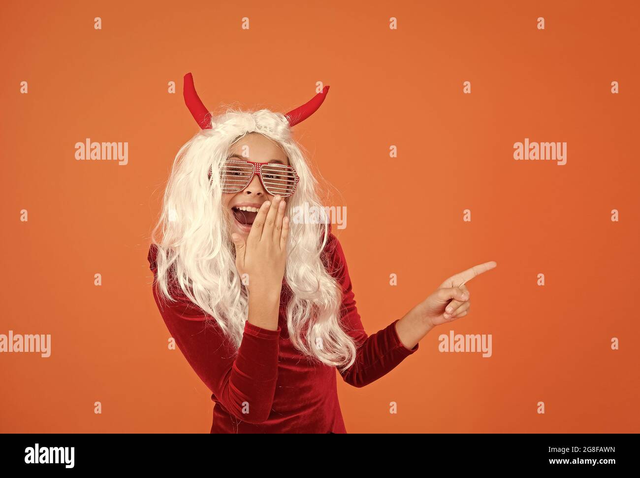 halloween devil kid in imp horns wear party glasses and pointing finger ...
