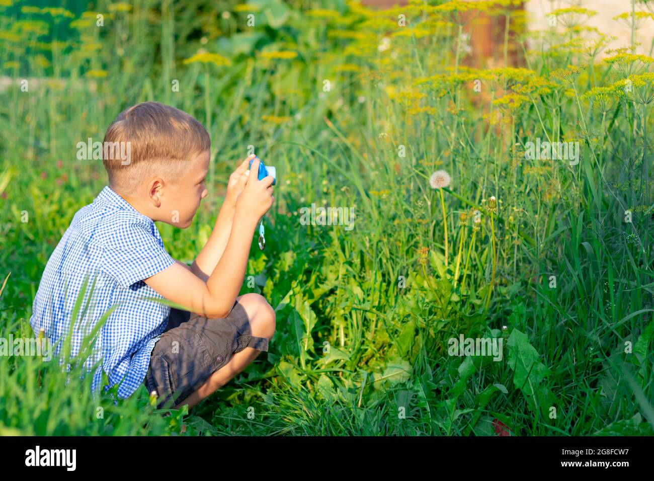 A cute preschool boy with a neat hairstyle in a blue shirt takes ...
