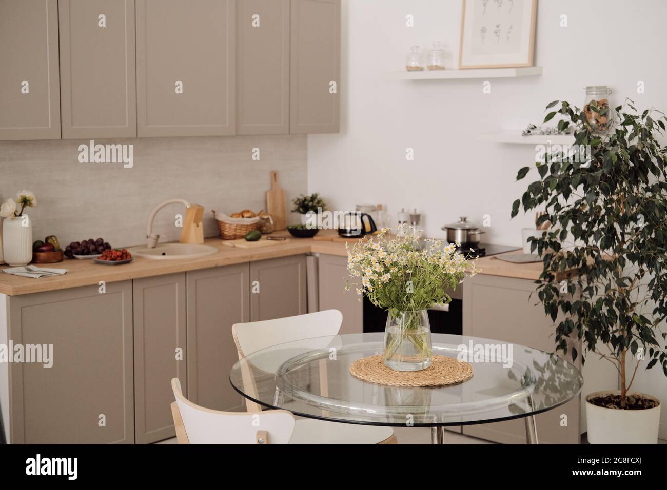 Interior of modern kitchen with chairs around table in the center Stock ...
