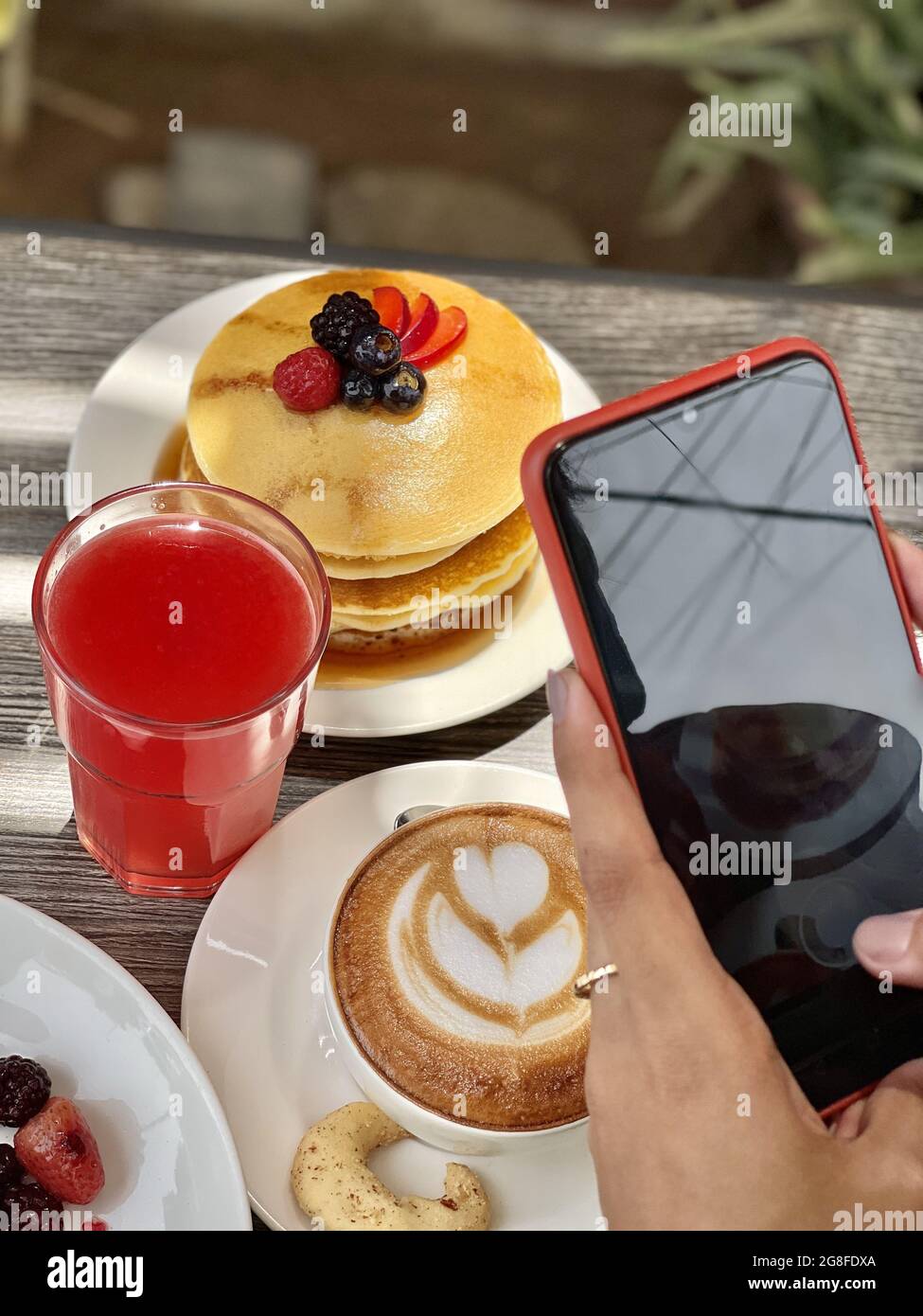 Vertical shot of a person taking photos of the breakfast table with ...