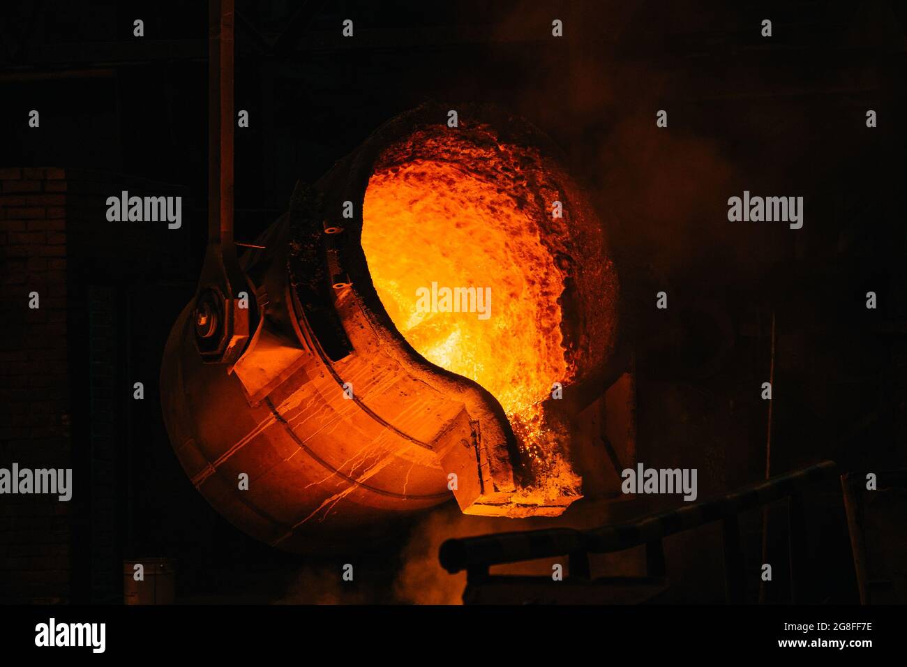 Ladle container with molten metal. Cast iron melting Stock Photo - Alamy