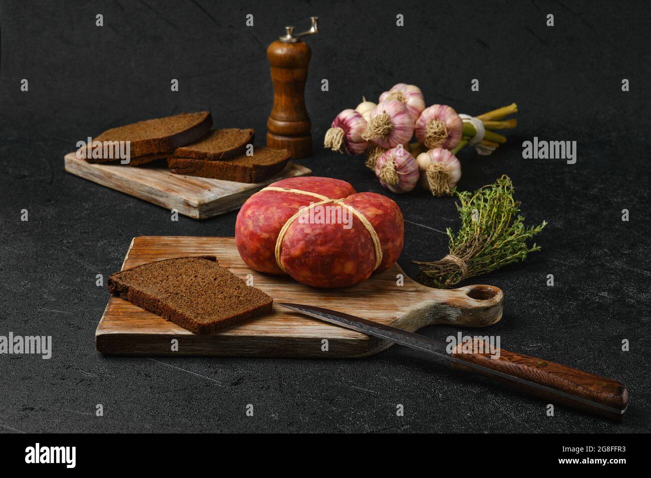Smoked round beef sausage on cutting board over black background Stock ...