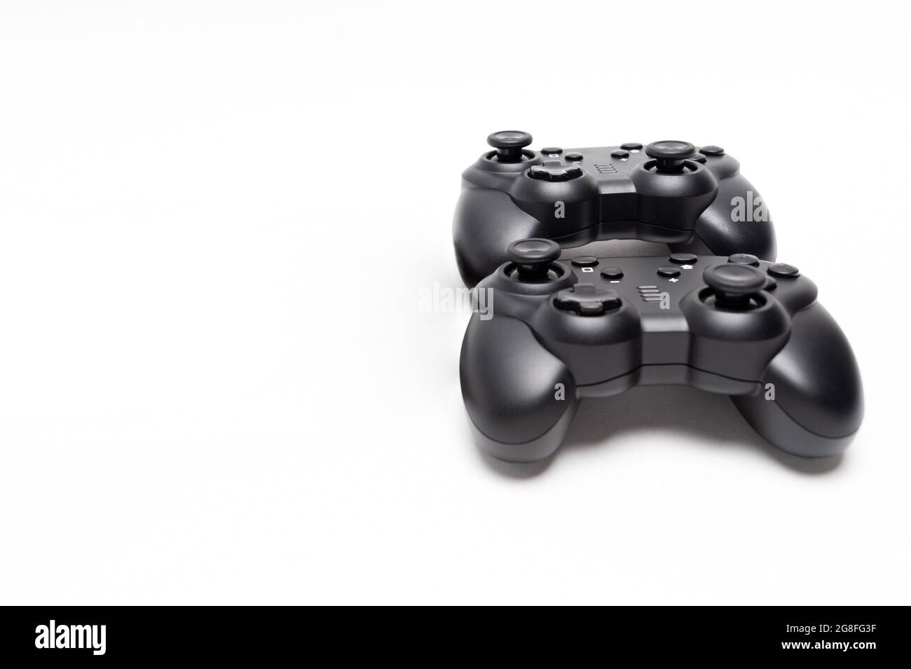 Two generic black gaming controllers. Isolated on white background ...