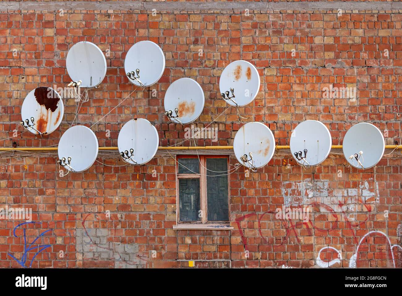 Many satellite dishes are attached to the wall of an old house Stock ...