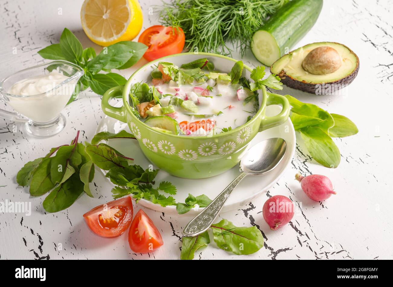 Summer cold raw food soup, okroshka in bowl on white wooden background ...