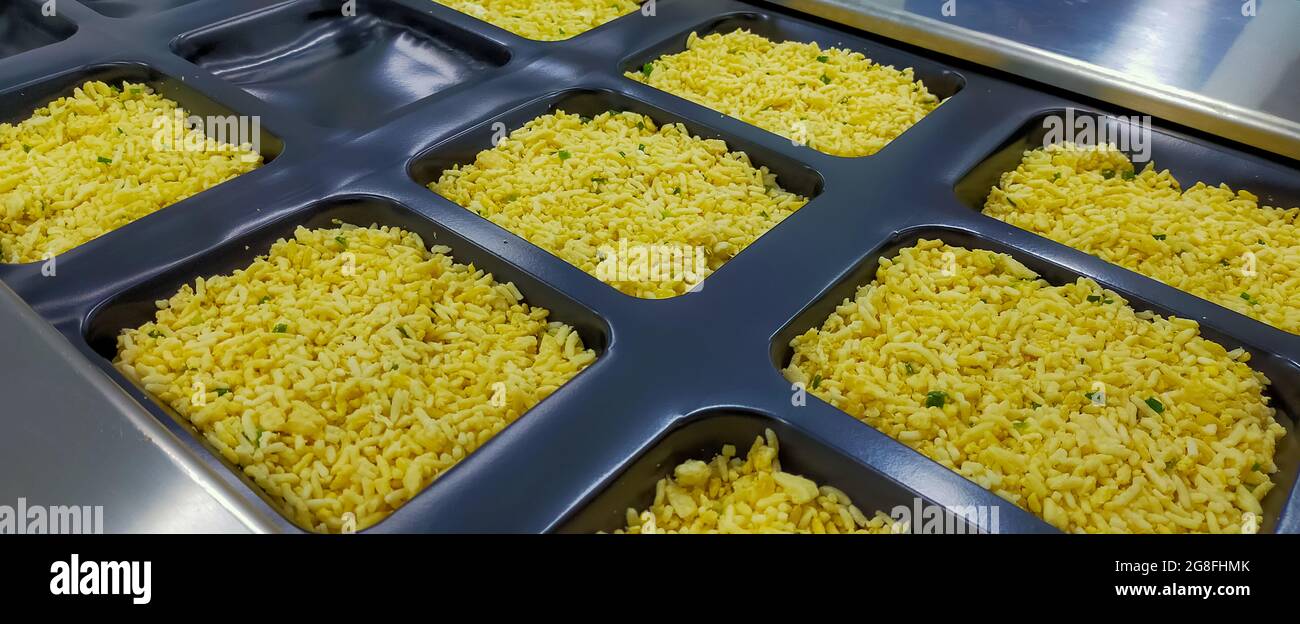 Frozen fried rice with egg in plastic tray waiting for top seal label ...