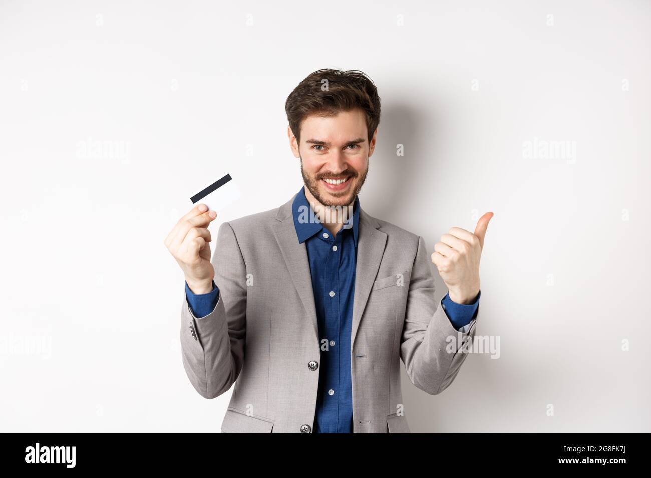Happy bank client in business suit showing plastic credit card and ...