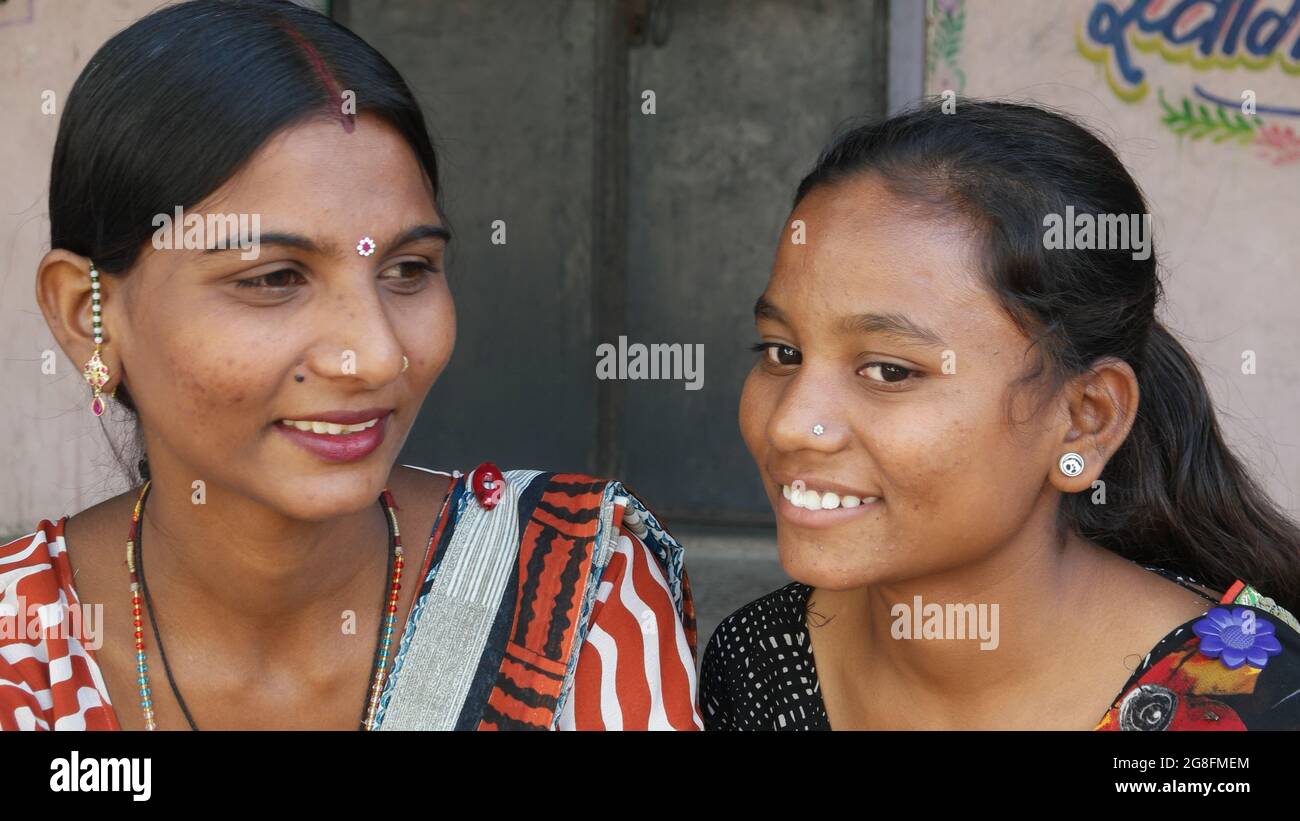 Happy Indian girls in traditional clothes sitting outdoor and talking ...