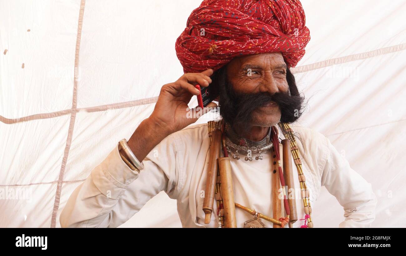 Elderly Indian man wearing traditional clothing and a pagri while ...