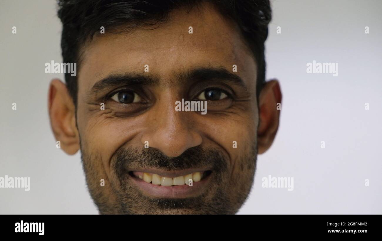 Closeup of a South Asian middle-aged man looking directly into the ...
