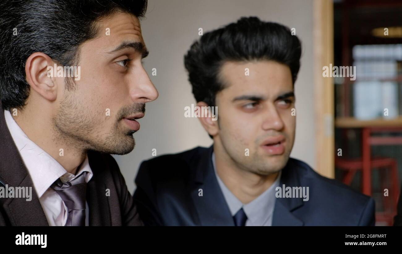 Indian colleagues sitting around a table and discussing their work ...