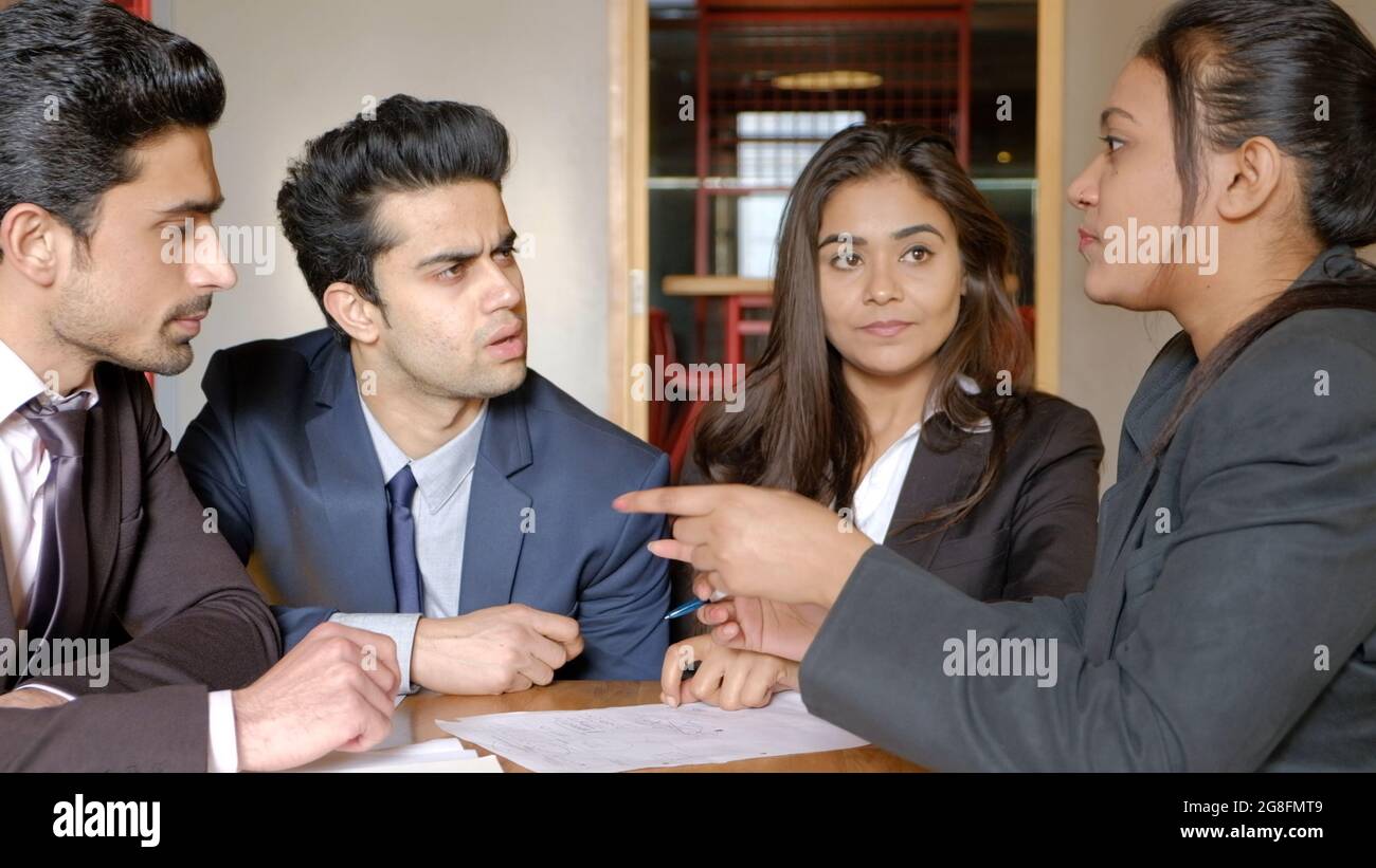 Indian colleagues sitting around a table and discussing their work ...