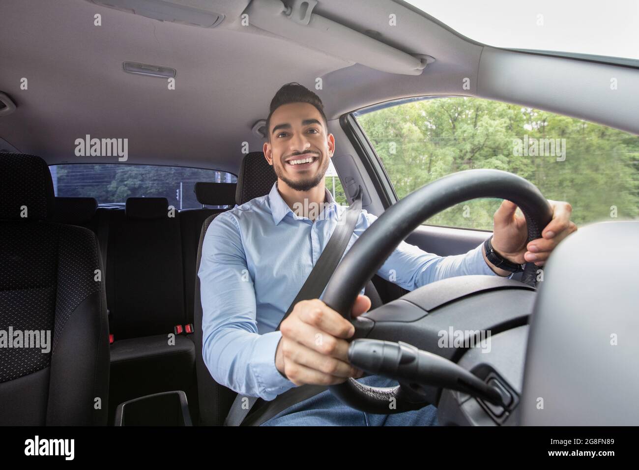 Smiling arab guy driving his car, shot from dashboard Stock Photo - Alamy
