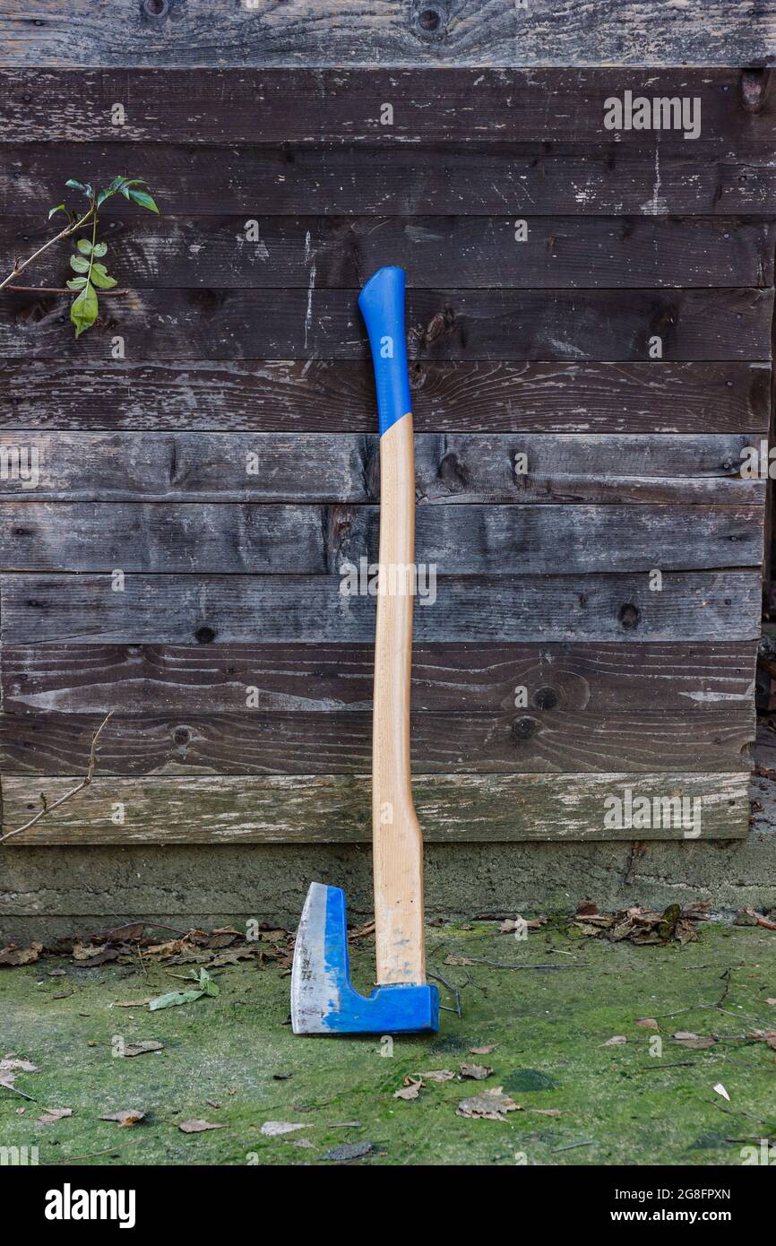 Vertical shot of an ax on wooden background Stock Photo - Alamy