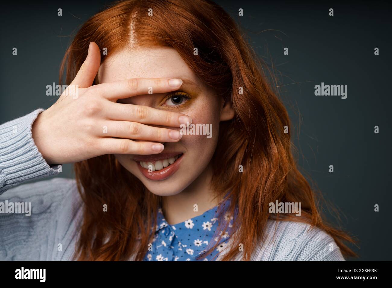 Young ginger happy woman smiling and covering her face isolated over ...