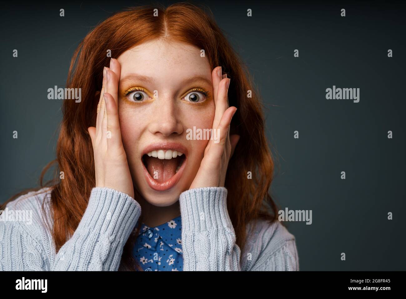 Young ginger excited woman expressing surprise at camera isolated over ...