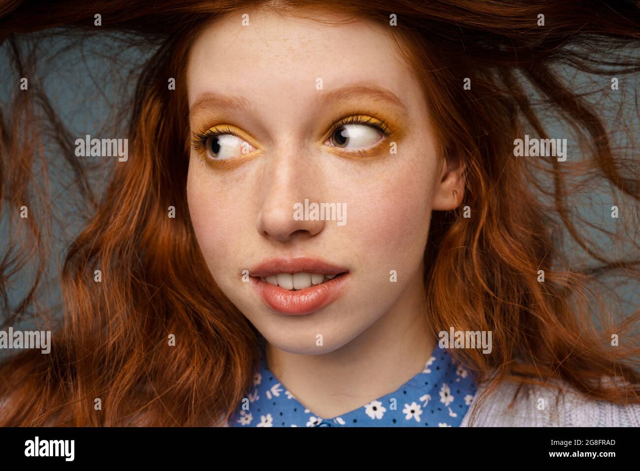 Young ginger white woman with makeup posing and looking aside isolated ...