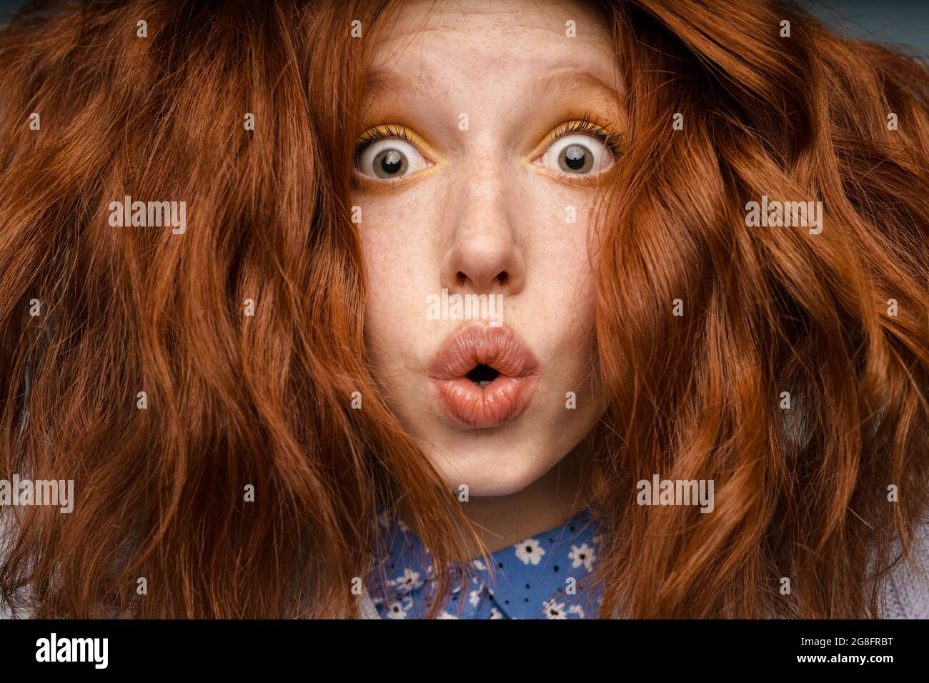 Young Ginger Shock Woman With Makeup Expressing Surprise At Camera