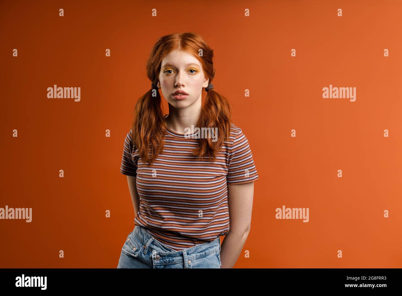 Ginger young woman with tails posing and looking at camera isolated ...