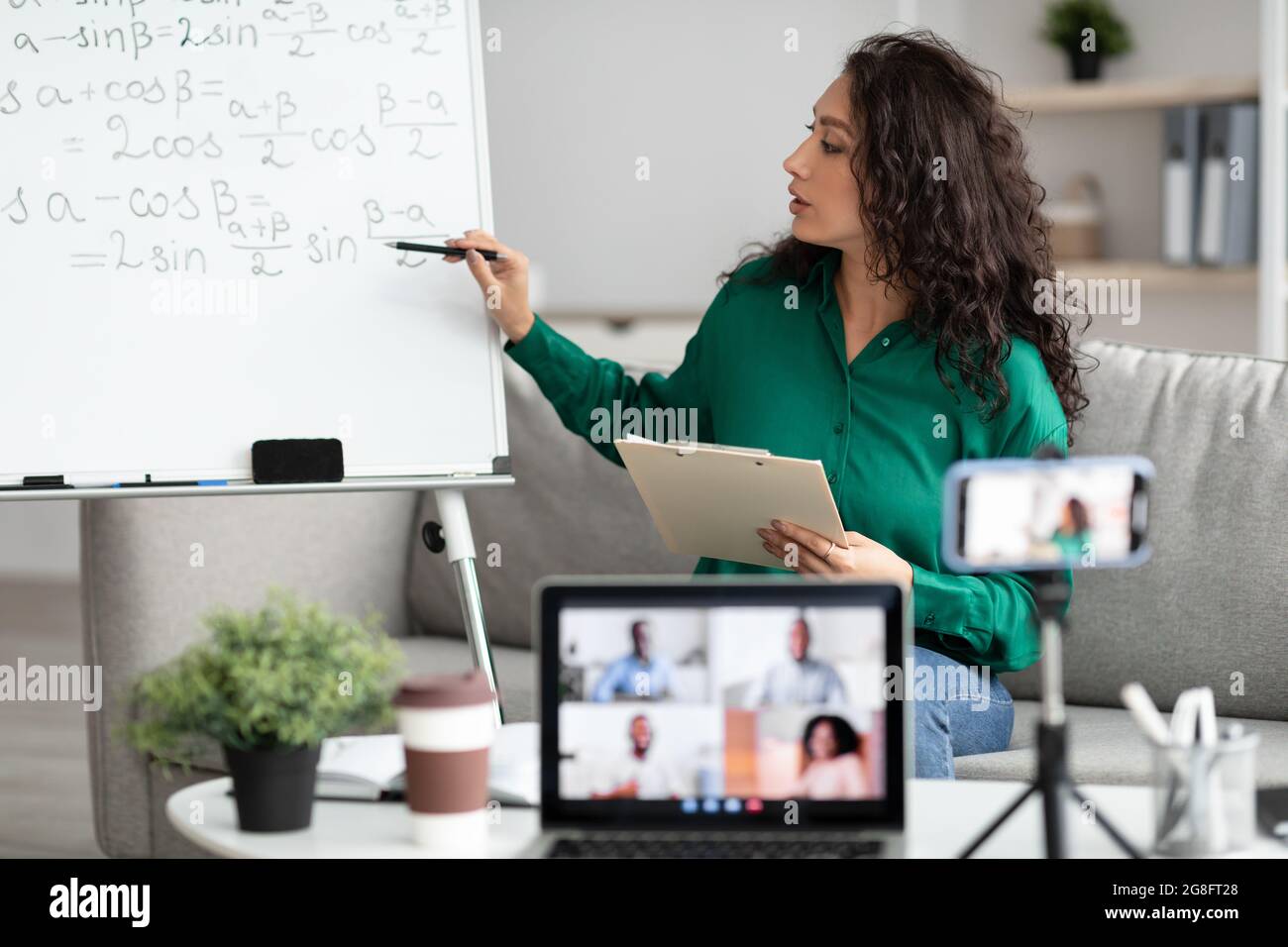 Math teacher pointing on board, giving virtual lecture to students ...