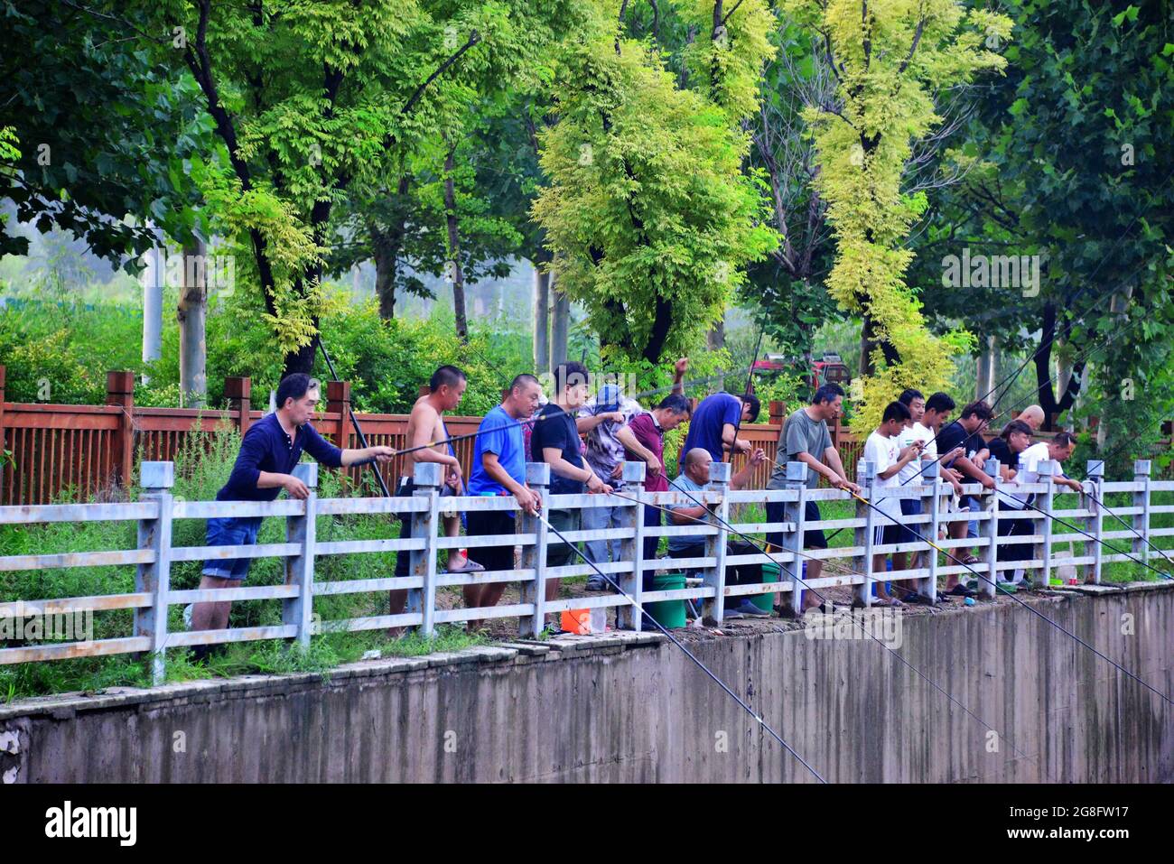 BEIJING, CHINA - JULY 19, 2021 - Villagers fish in a ditch at a wetland ...