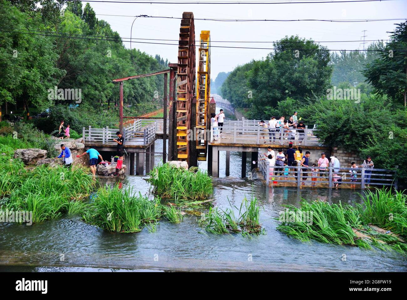 BEIJING, CHINA - JULY 19, 2021 - Villagers fish in a ditch at a wetland ...