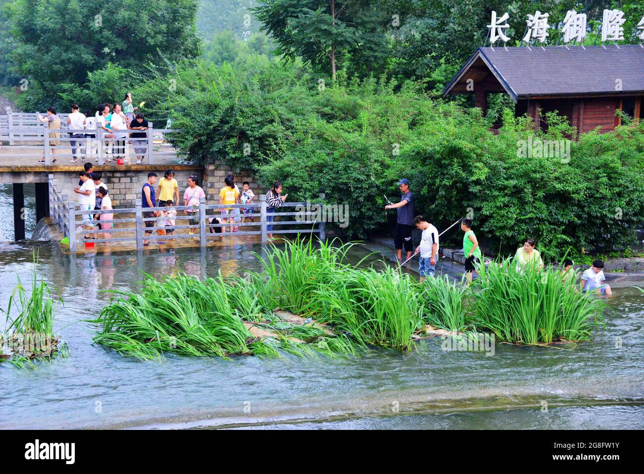 BEIJING, CHINA - JULY 19, 2021 - Villagers fish in a ditch at a wetland ...