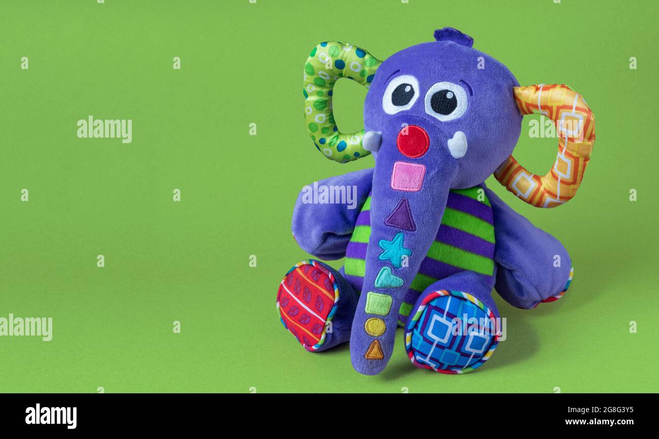 Violet elephant tactile educational toy sits on a bright green ...